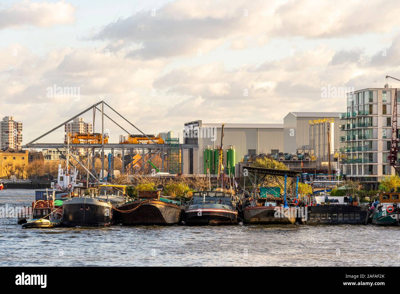 Boats and barges moored at Tower Bridge Moorings at Downings Roads with ...