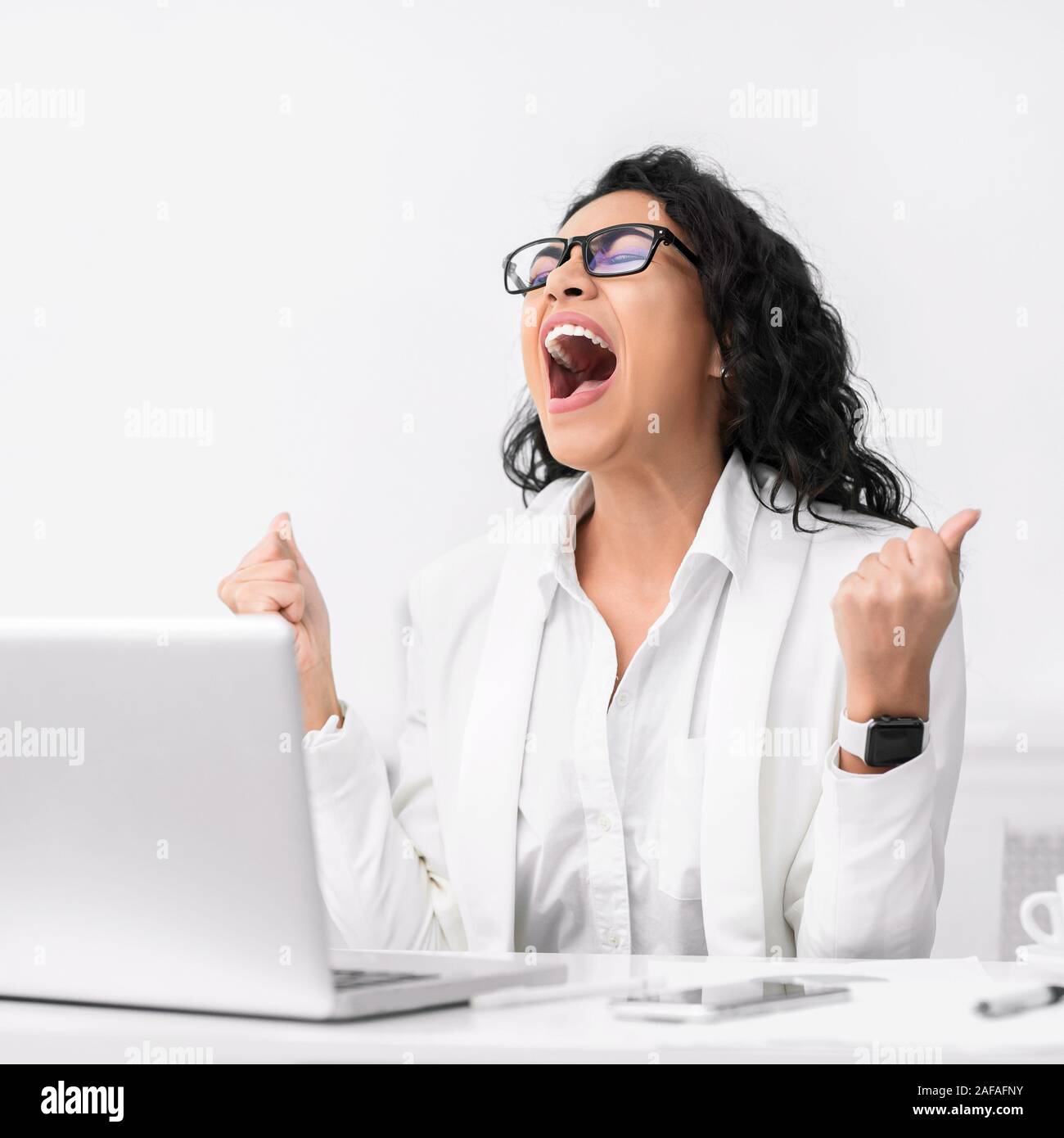 Happy hispanic girl yelling at work place Stock Photo - Alamy
