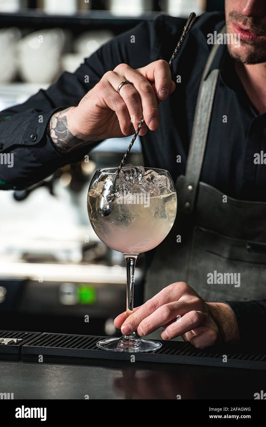bartender making refreshing ruby red coctail with grape fruit isolated ...