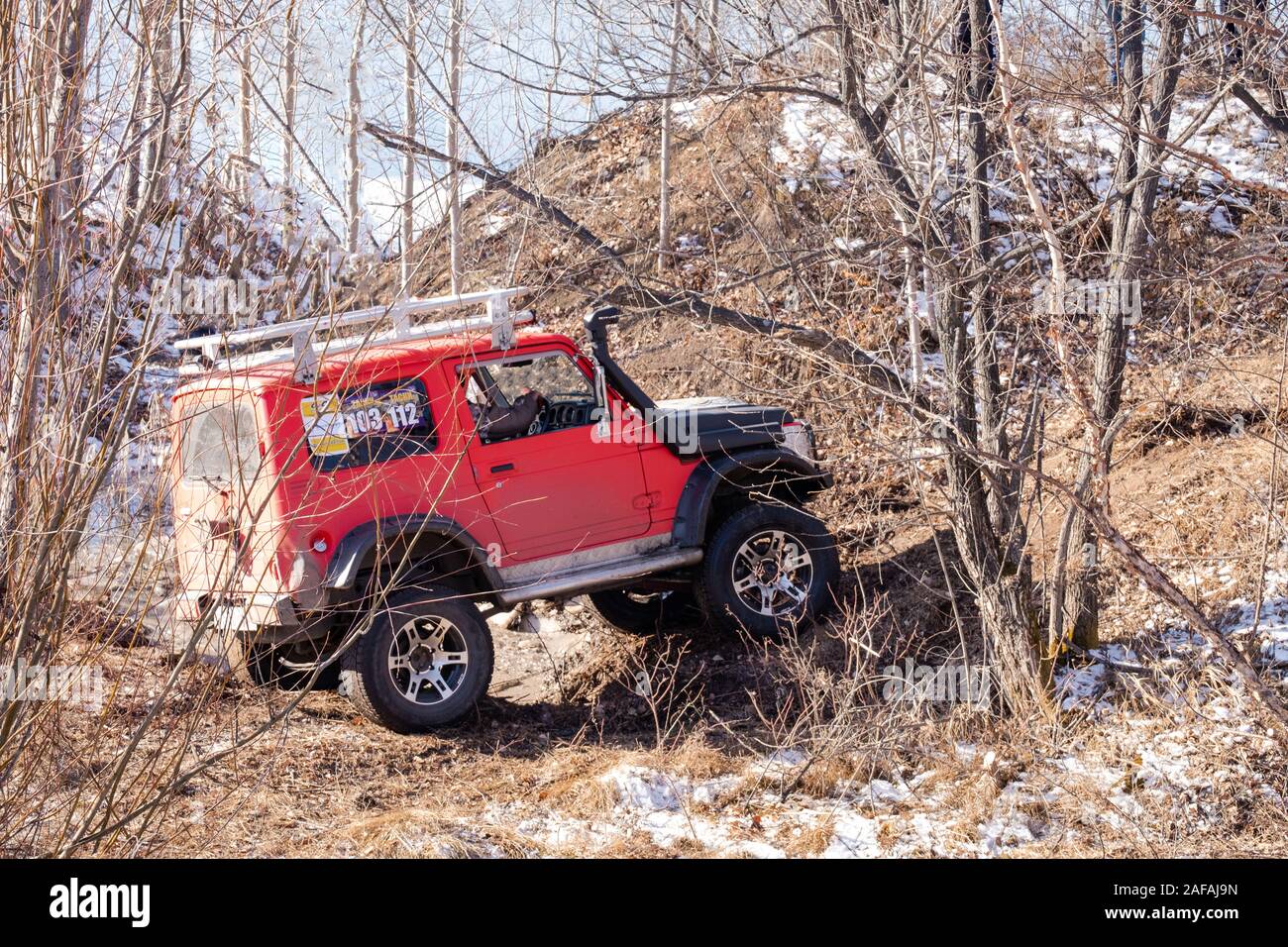 Jeep Suzuki Jimny overcomes obstacles in the forest Stock Photo - Alamy