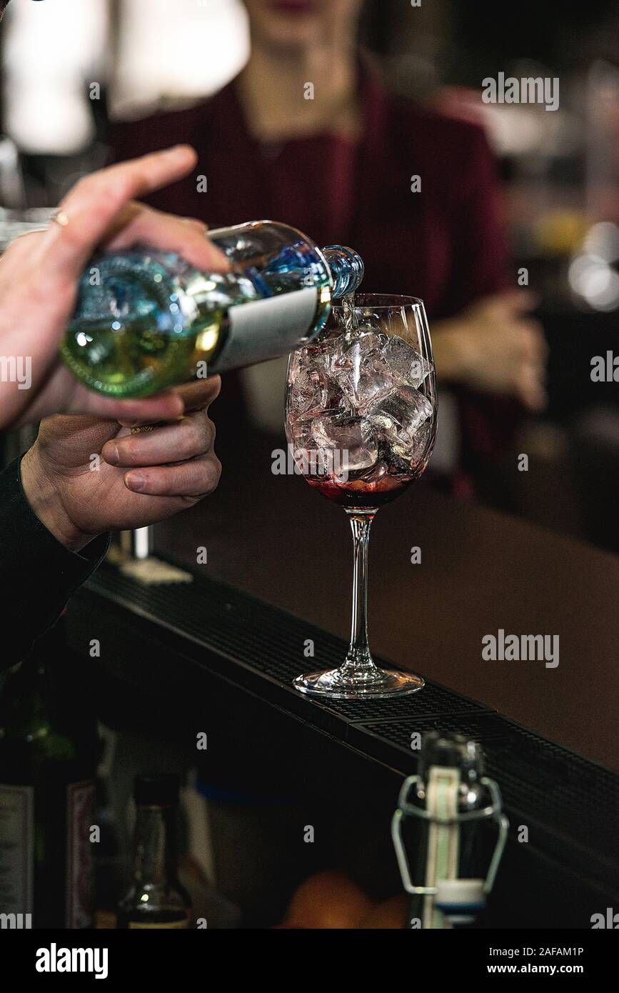 bartender making refreshing pink coctail with a rose on top isolated on ...