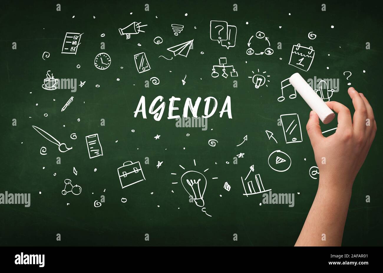 Hand drawing AGENDA inscription with white chalk on blackboard ...