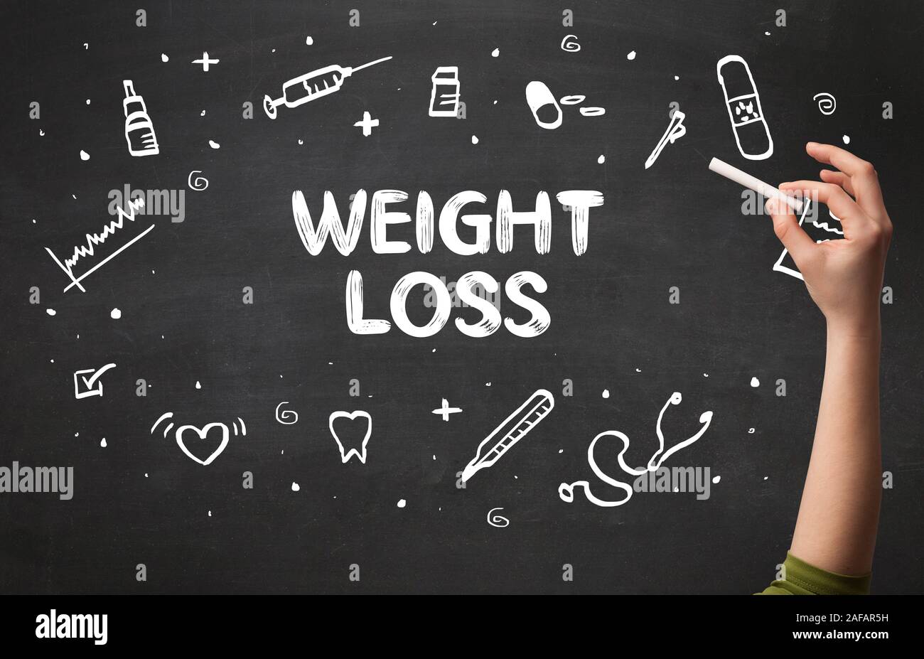 Hand drawing WEIGHT LOSS inscription with white chalk on blackboard ...