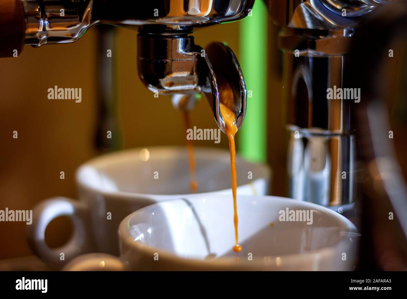 A portrait of freshly made coffee running out of a portafilter from a ...