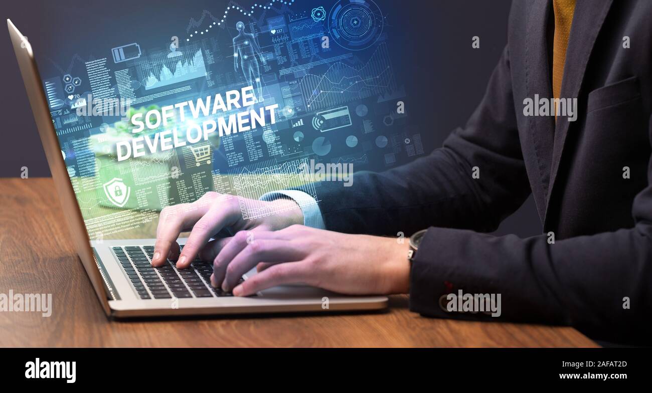 Businessman working on laptop with SOFTWARE DEVELOPMENT inscription ...