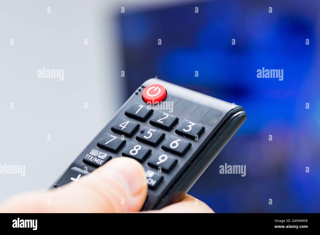 TV remote controls in hand Stock Photo - Alamy