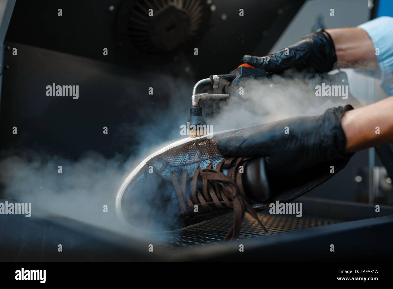 Shoemaker processes the shoes on special machine Stock Photo - Alamy