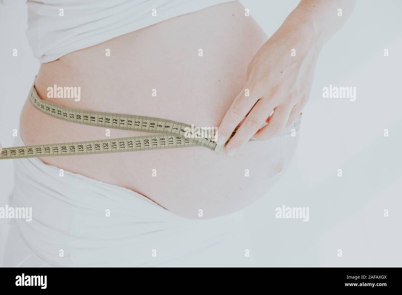 the stomach of a pregnant woman and a measuring tape Stock Photo - Alamy