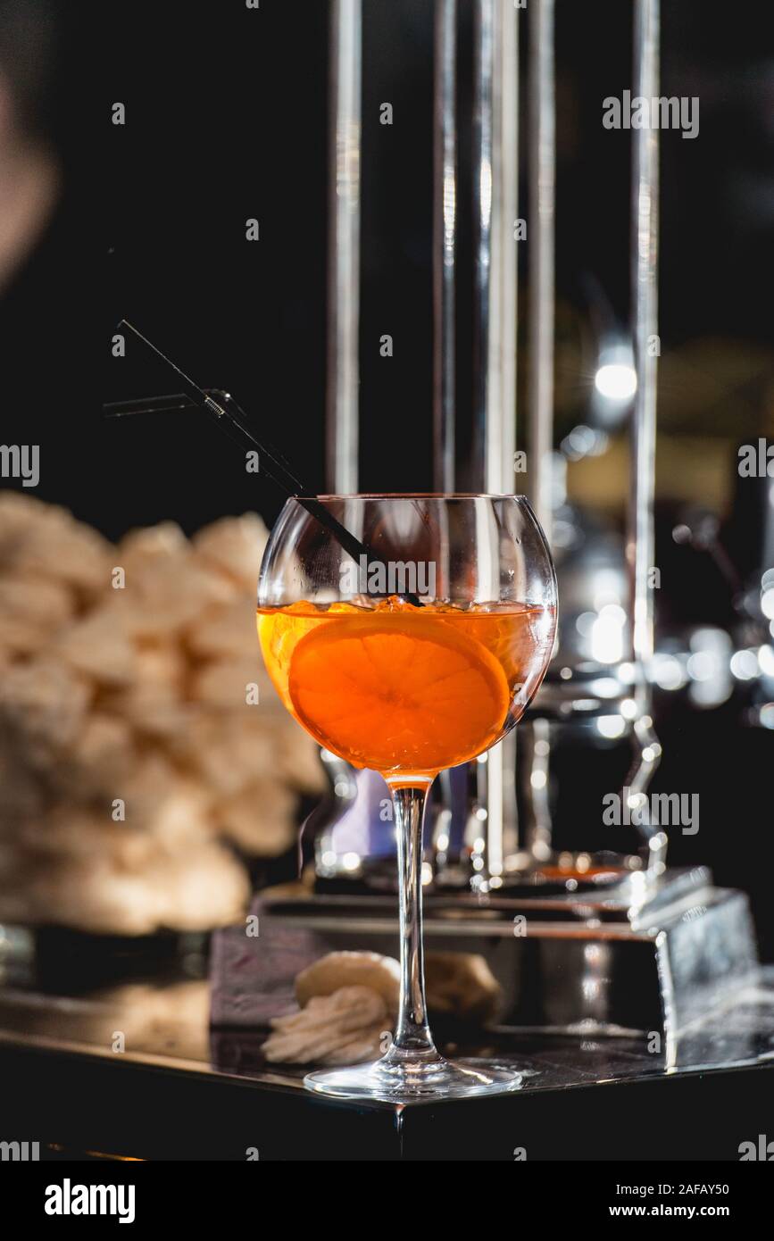 glass of refreshing orange alcoholic cocktail on a table in the bar ...
