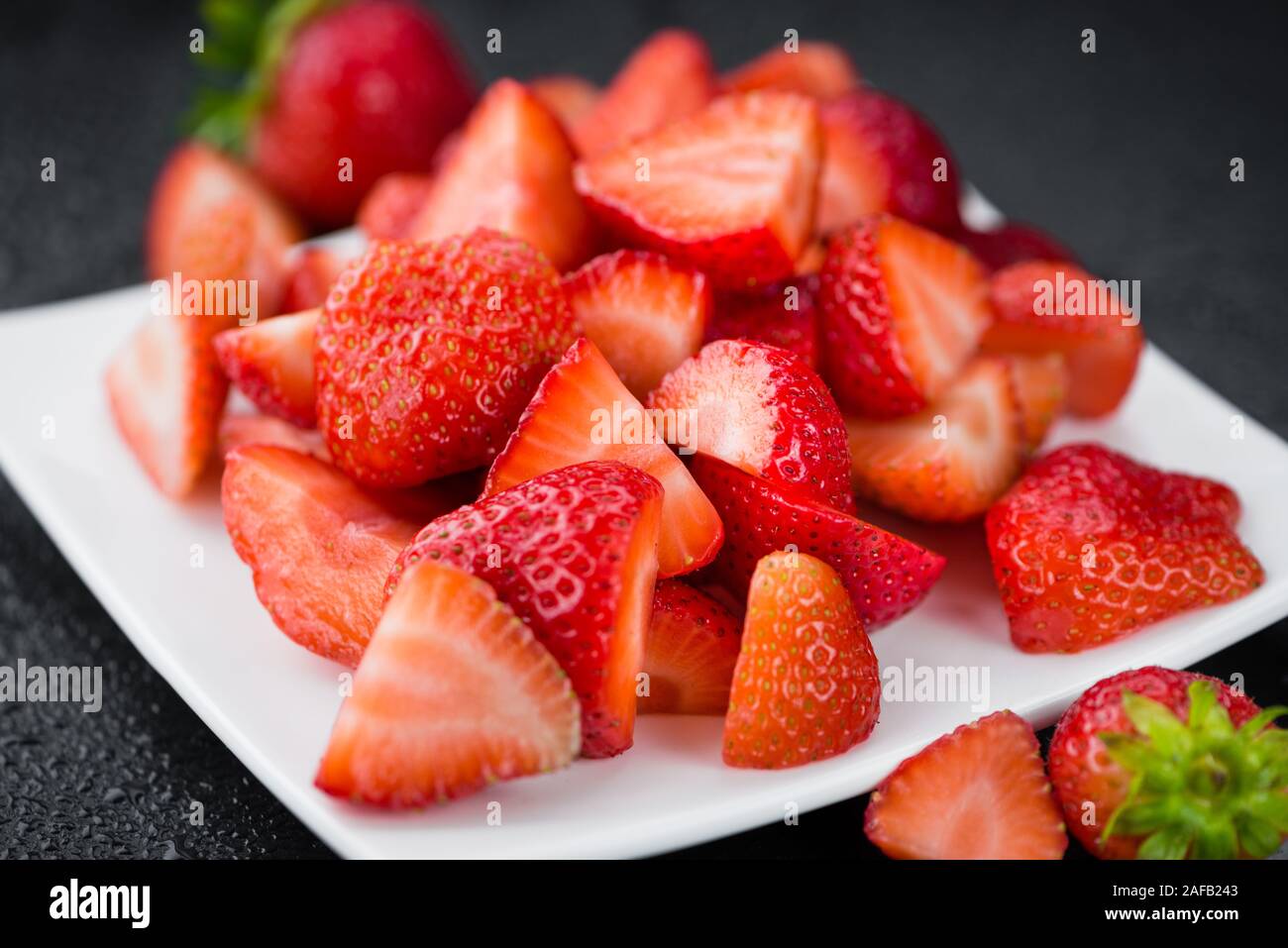 Sliced Strawberries on a vintage slate slab as detailed close-up shot ...