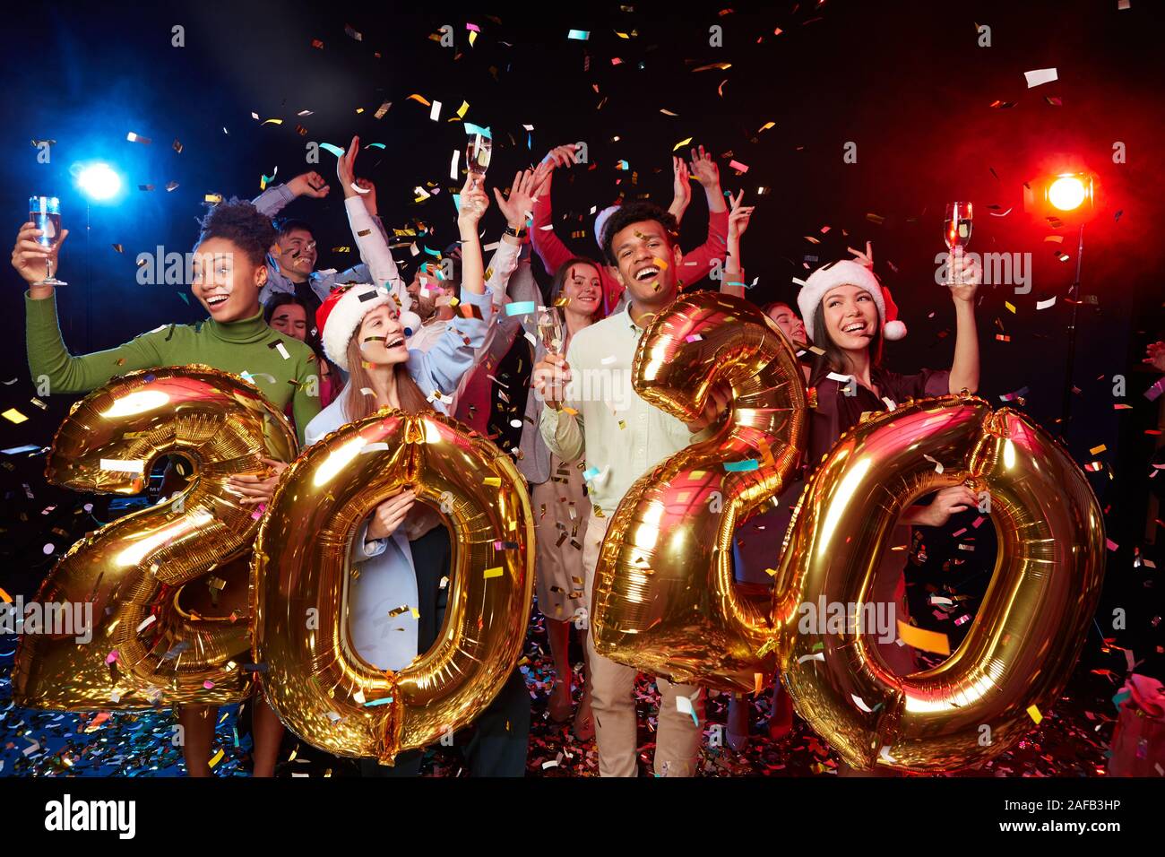 Happy New Year. Group of happy multiethnic people holding gold colored ...