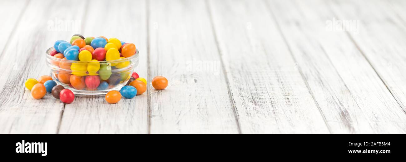 Cocolate coated Peanuts on rustic wooden background (close-up shot ...
