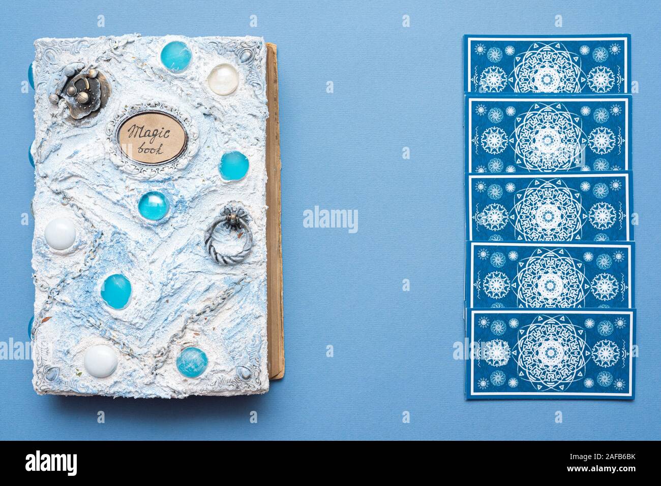 Magic book and tarot cards on blue flat lay background Stock Photo - Alamy