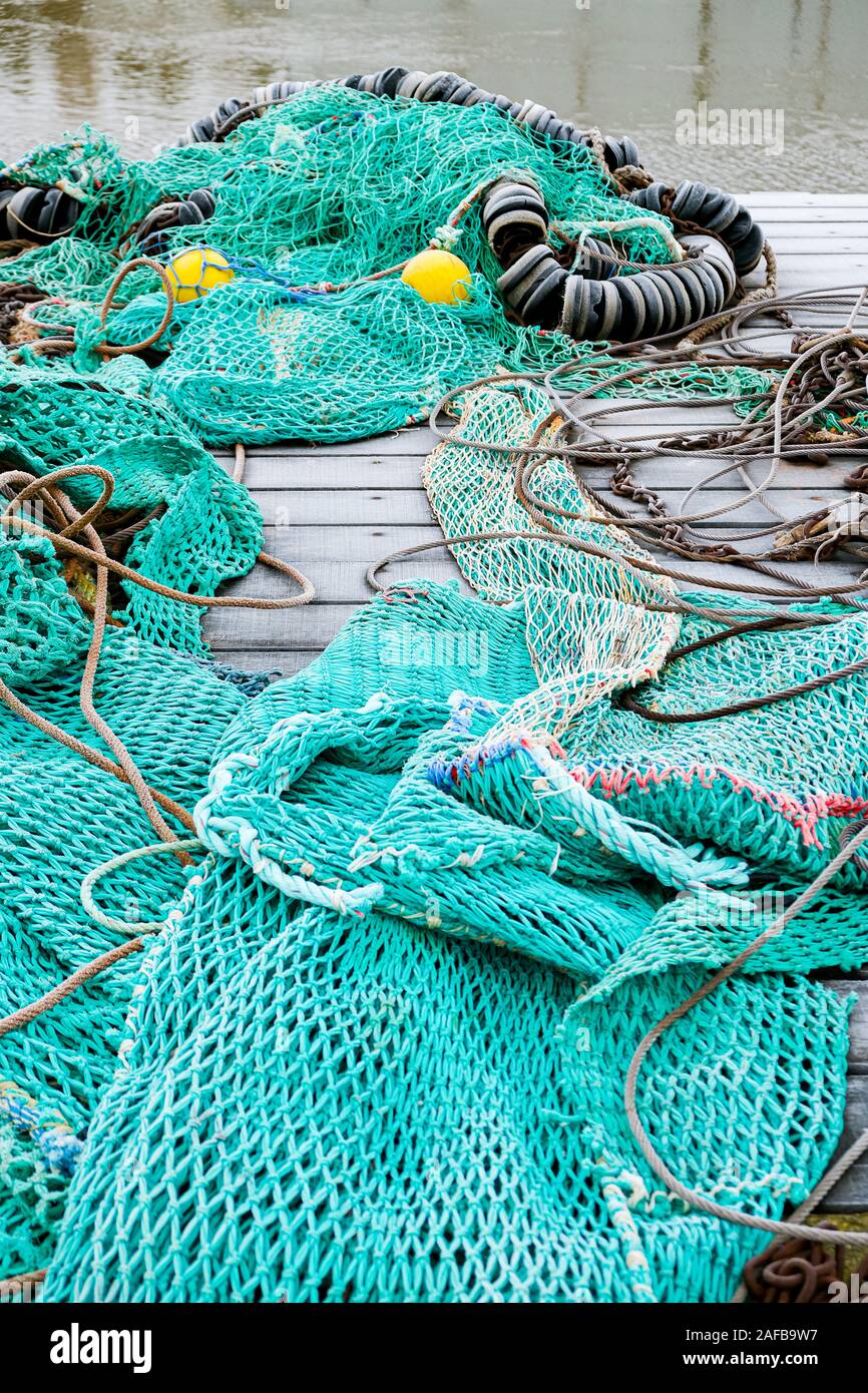blue fishing net on a pontoon with its ropes and floats covered with ...