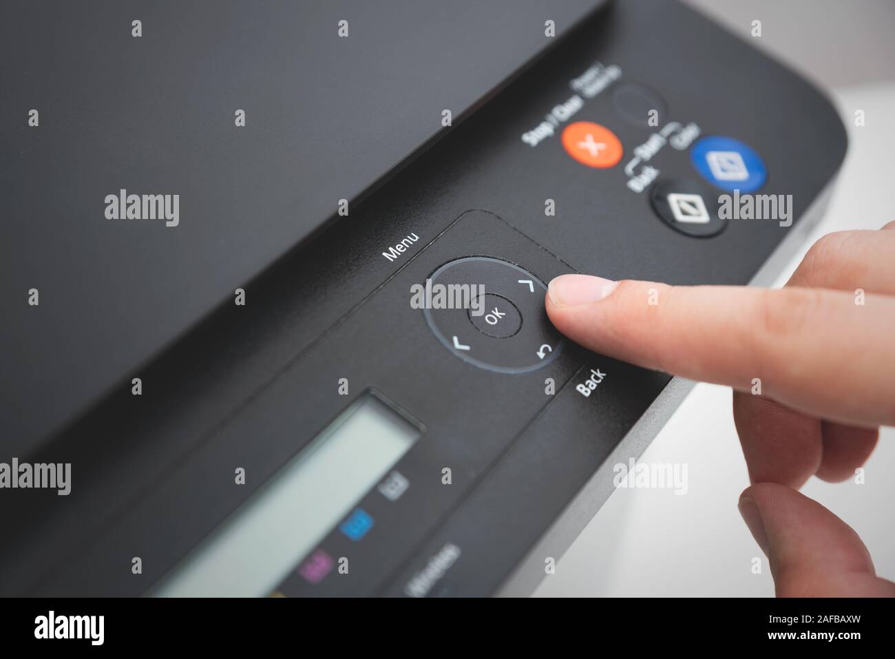 Hand pressing button on panel of printer. Multifunction device, printer ...