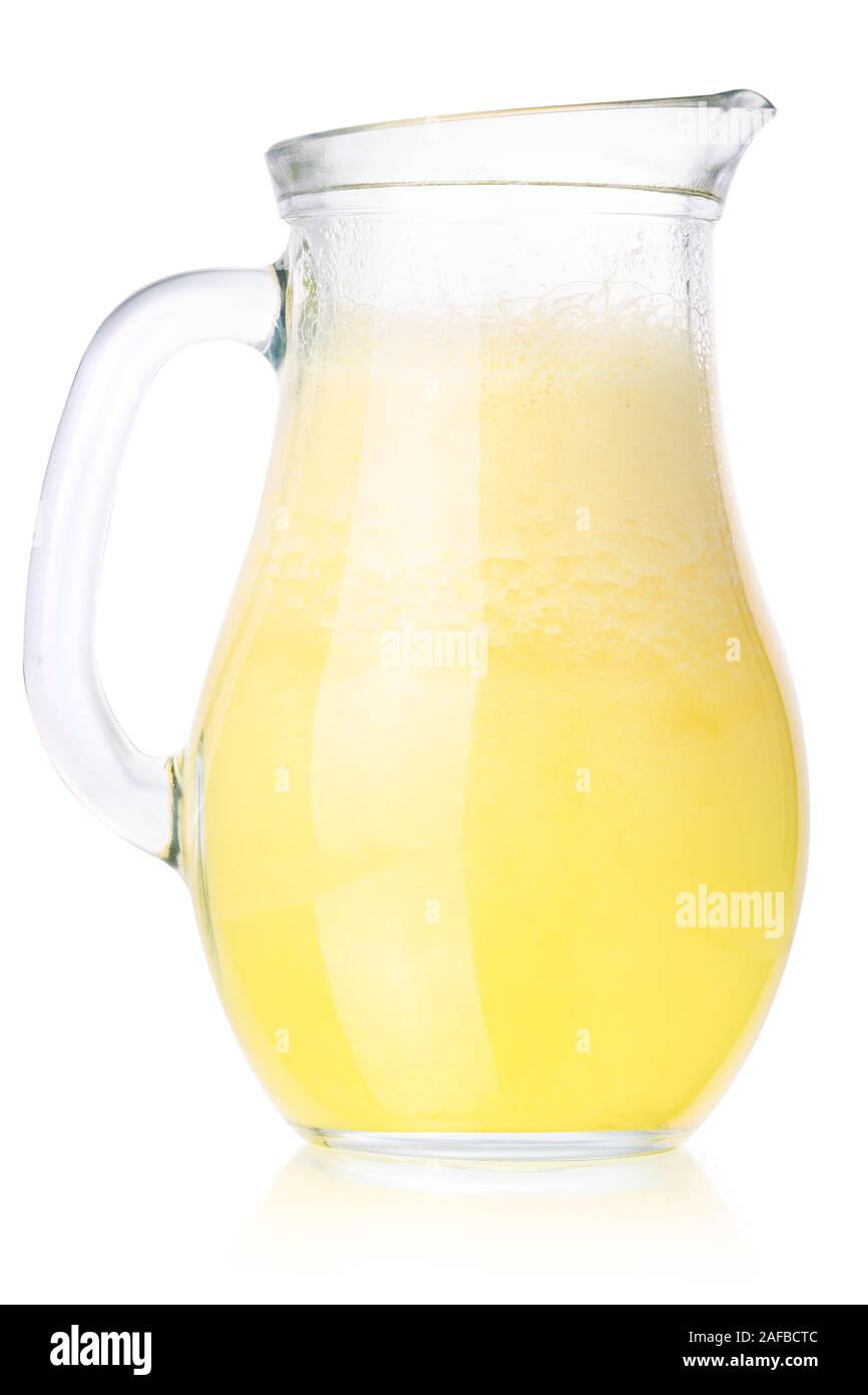 Pineapple smoothie or freshly pressed juice in a glass pitcher isolated ...
