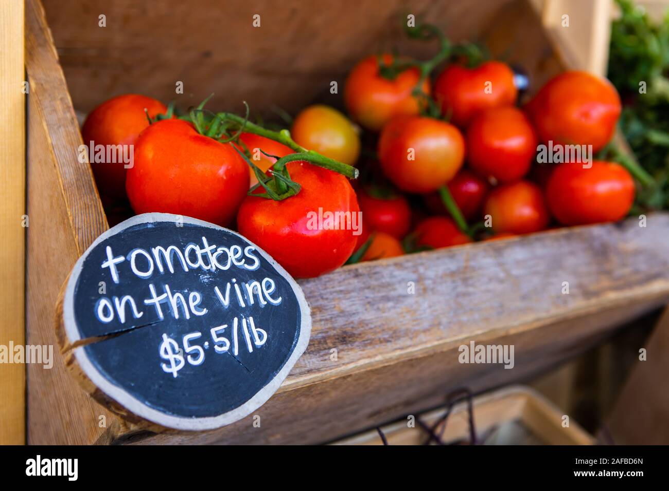 A close up view of a price sign advertising ripe tomatoes on the vine ...