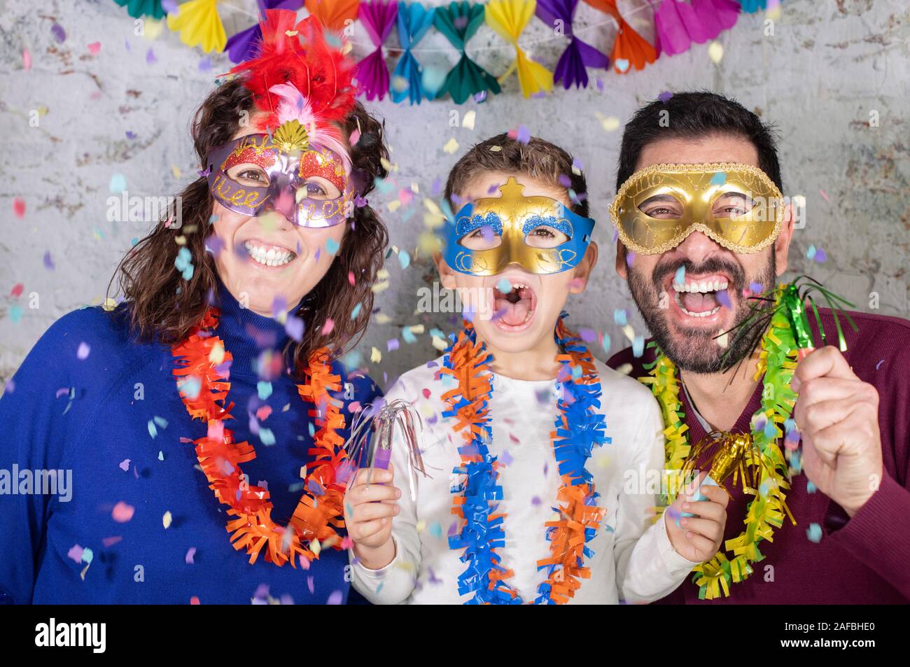 Happy family with masks celebrating Carnival Stock Photo - Alamy