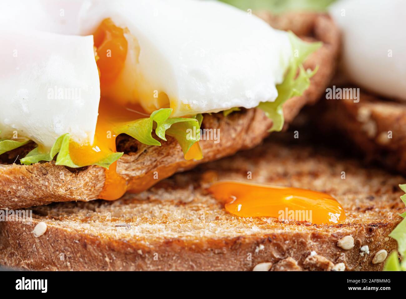 Poached egg yolk on cereal bread toast Stock Photo - Alamy