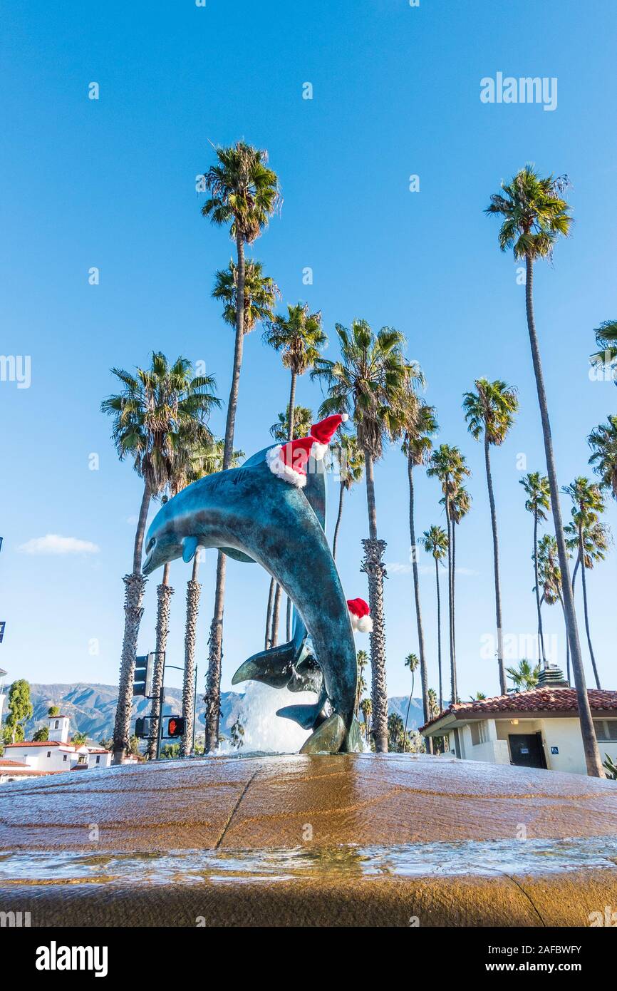 Sculpture of three bronze dolphins wearing red and white Santa hats for ...
