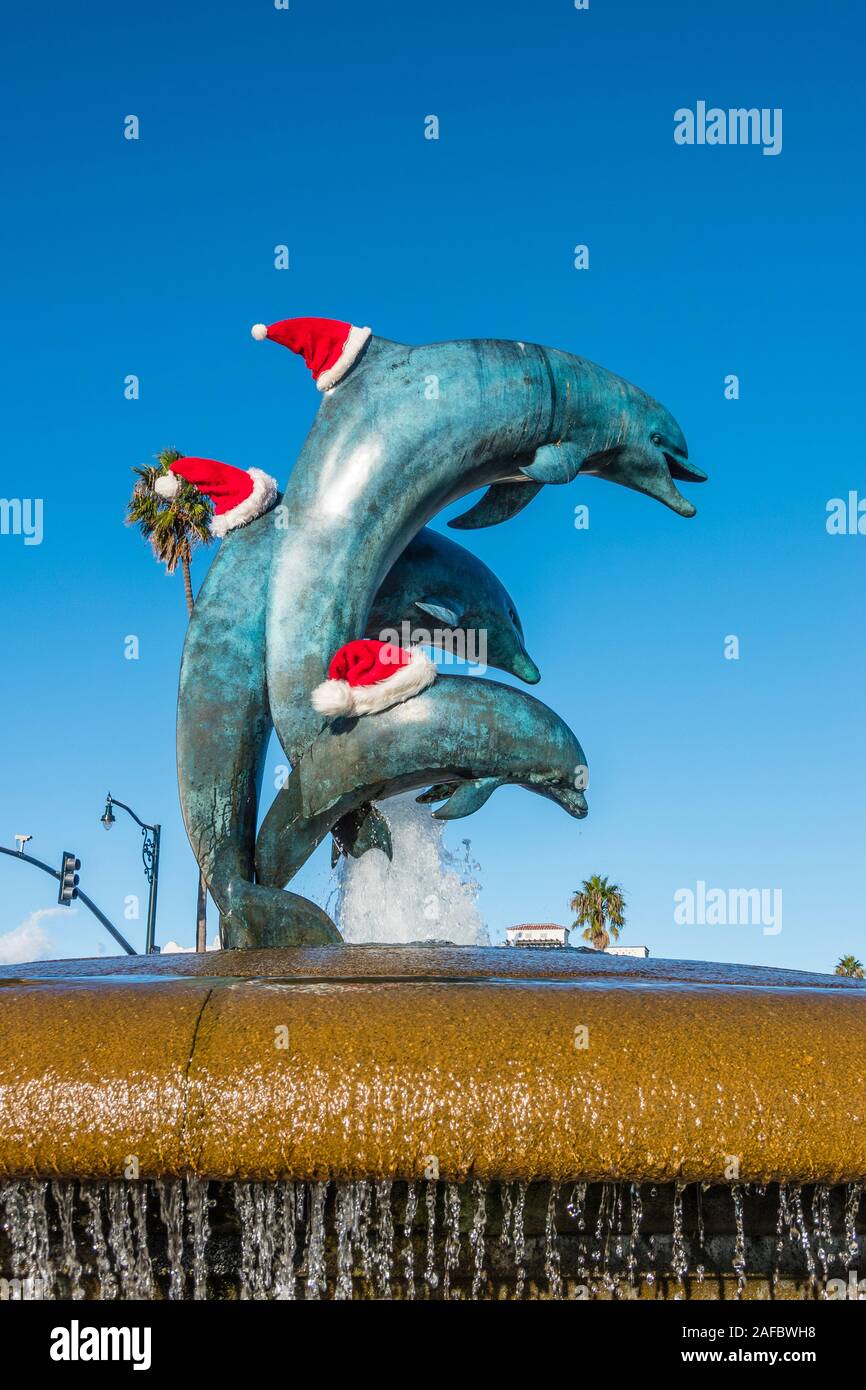 Sculpture of three bronze dolphins wearing red and white Santa hats for ...
