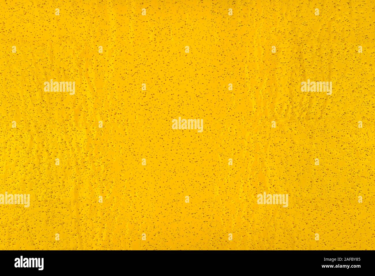 Real texture of yellow, rough material with small holes, illuminated ...