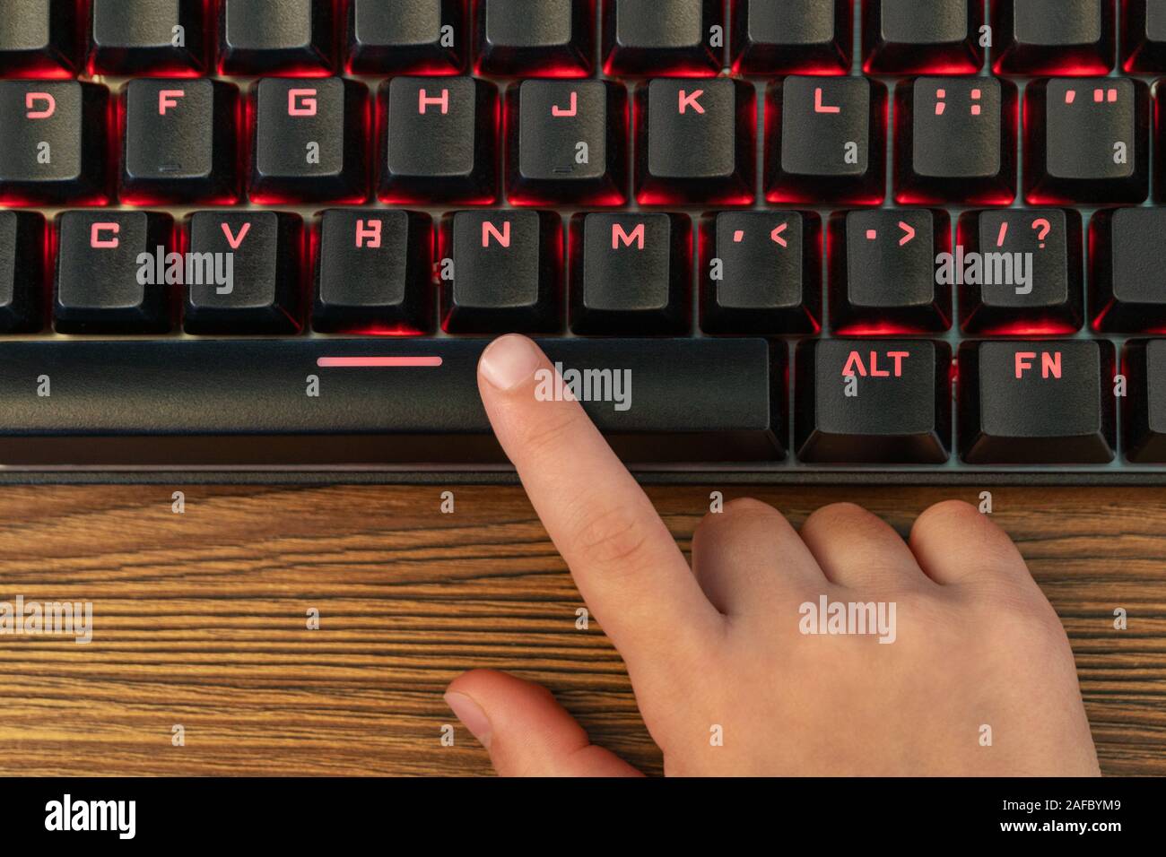child index finger presses the spacebar on the black keyboard Stock ...