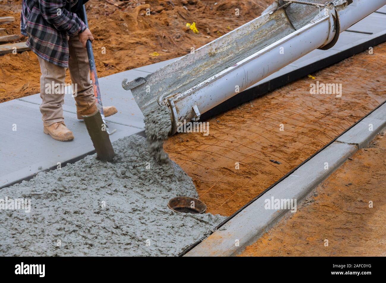 Truck loads of concrete pouring at construction into the concrete at a ...