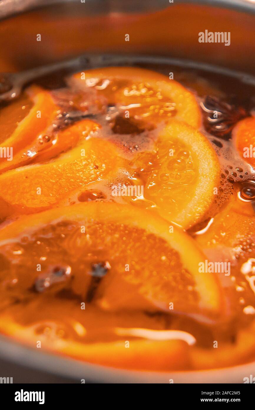 Making hot alcoholic mulled wine with oranges and spices. Christmas ...