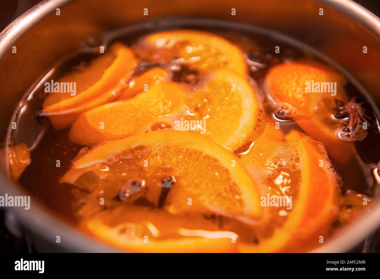 Making hot alcoholic mulled wine with oranges and spices. Christmas ...