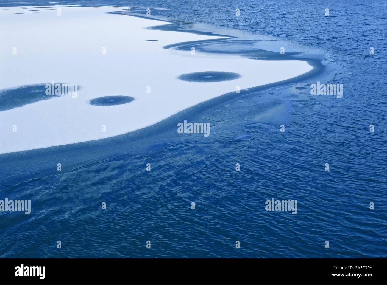 Frozen lake in early winter, part of the surface are covered with ice ...