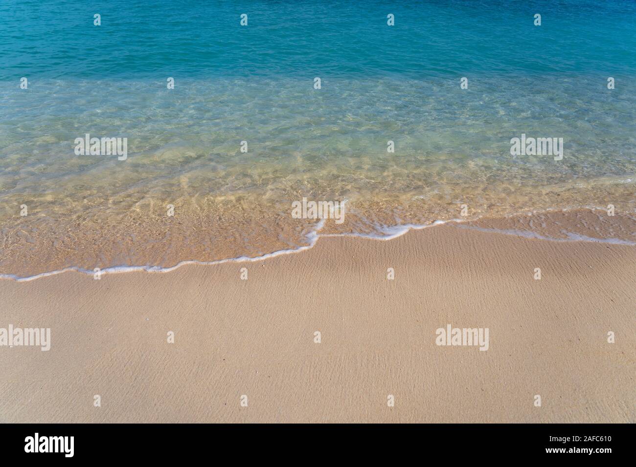 Turquoise blue water with waves gently rolling onto a sandy beach,Coron ...