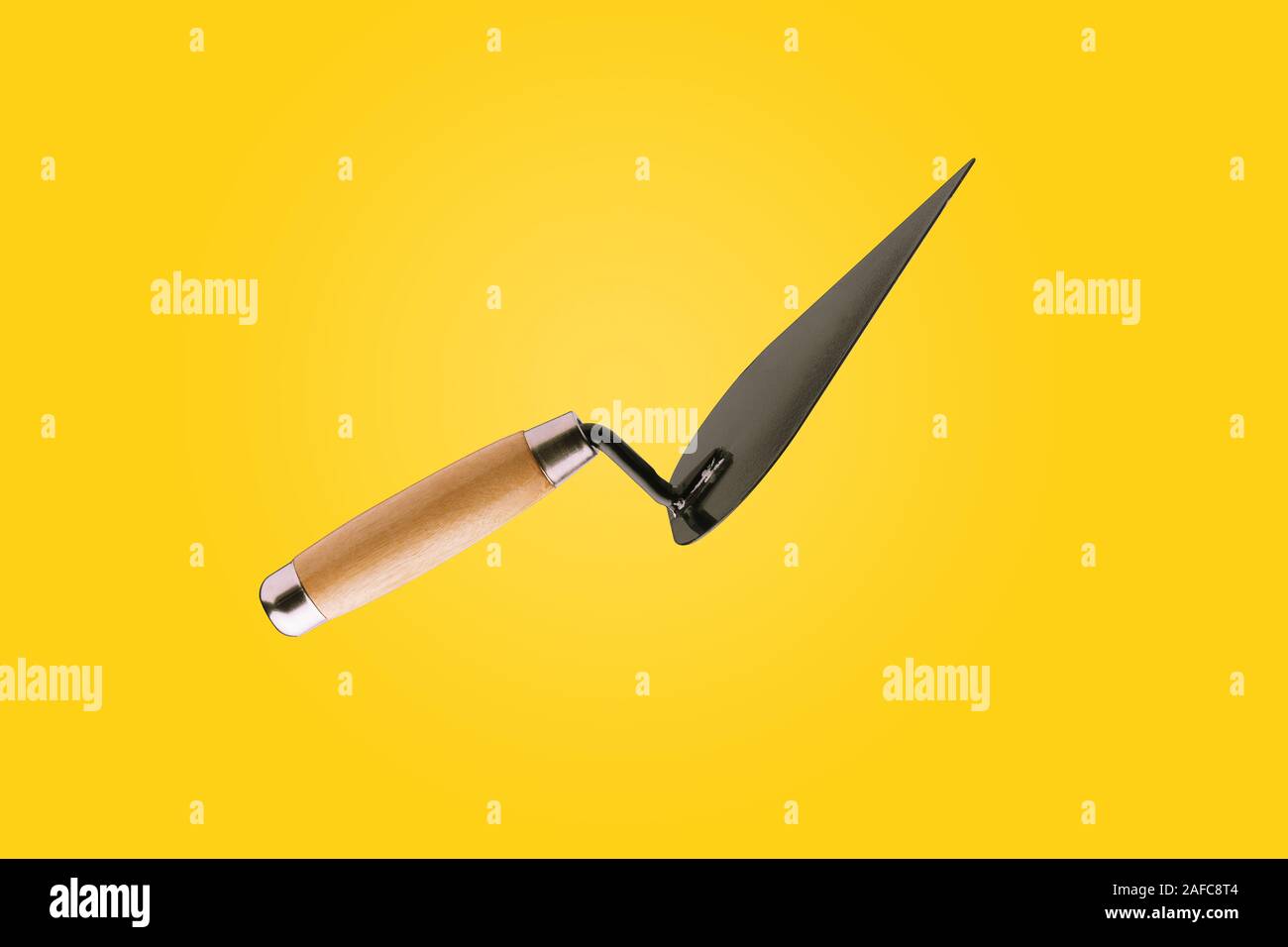 building spatula over yellow background Stock Photo - Alamy