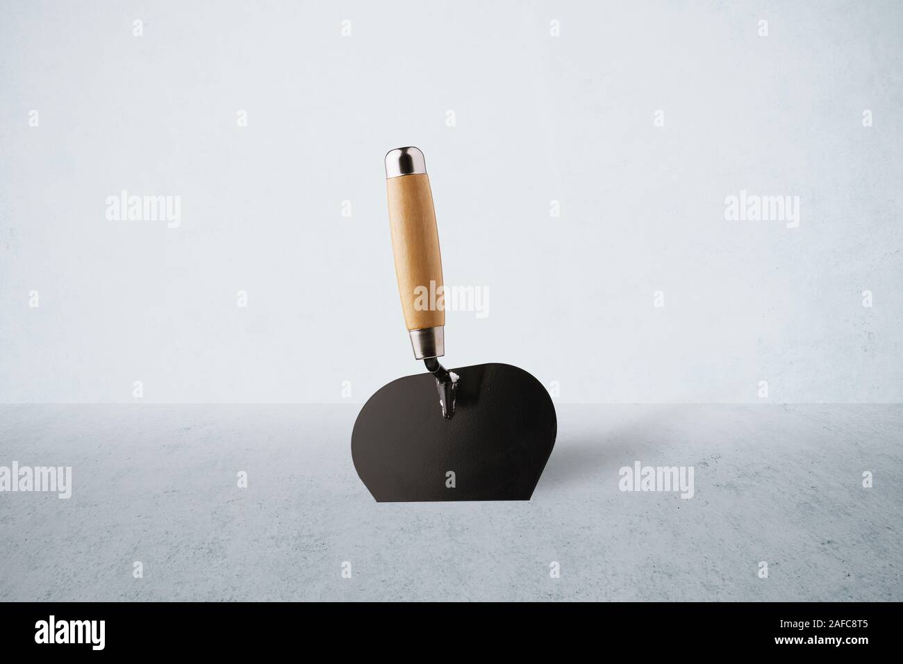 building spatula half in concrete floor, incomplete repair concept ...