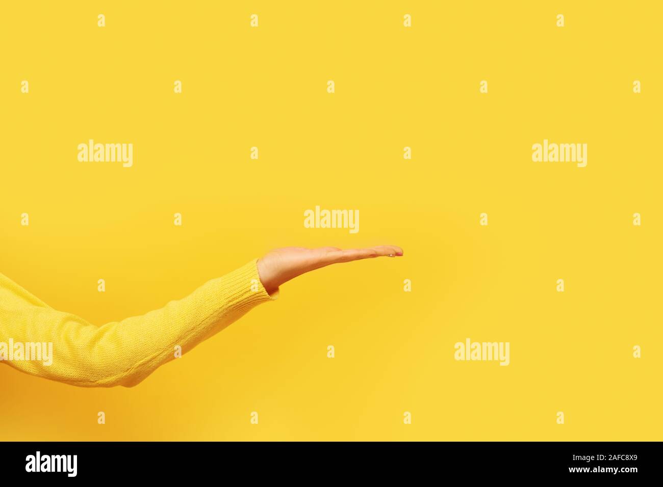 hand with palm up over yellow background, place for your advertisement ...