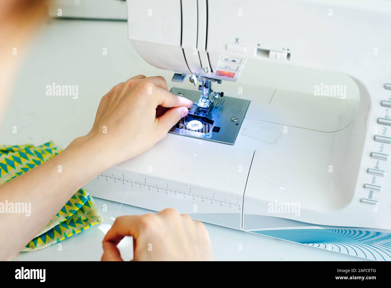 Female hands stitching white fabric on professional manufacturing ...
