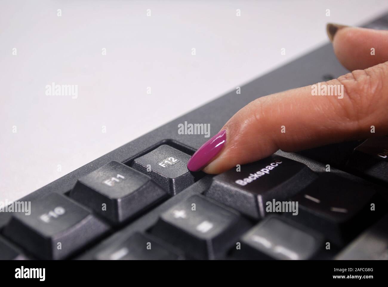 Hands are pressing black keyboard buttons,F12 button on the keyboard ...