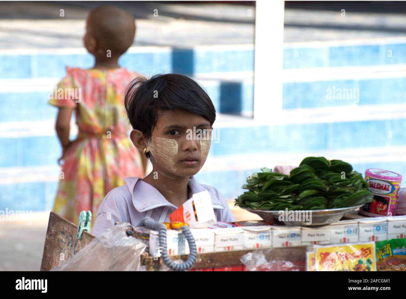 Girl with Thanaka beauty and sunscreen paste on her cheeks with bald ...