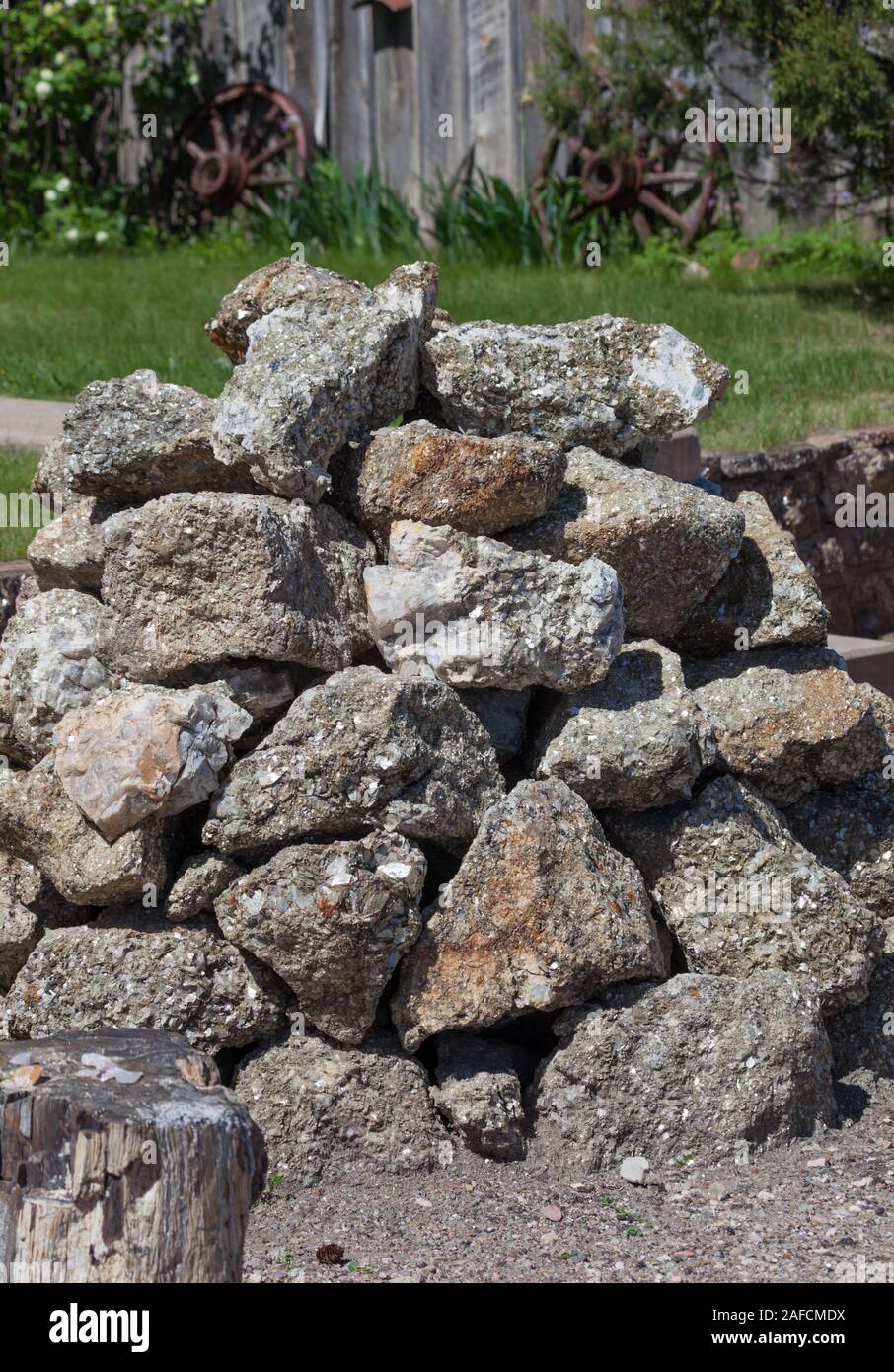 A pile of large mica and quartz rocks stacked in a pile in the sunshine ...