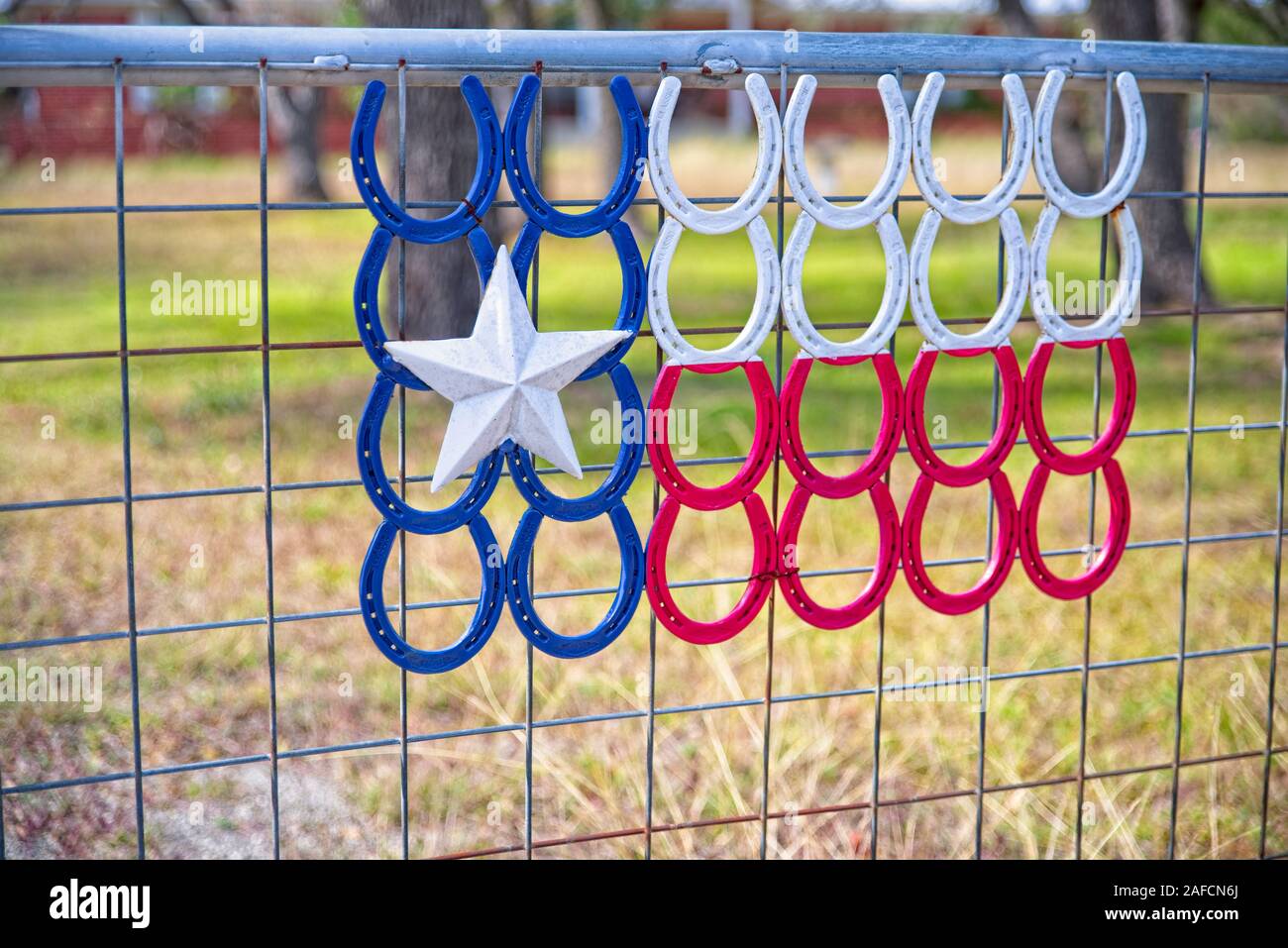 Texas Lone Star flag made with painted horseshoes decorates fence gate ...