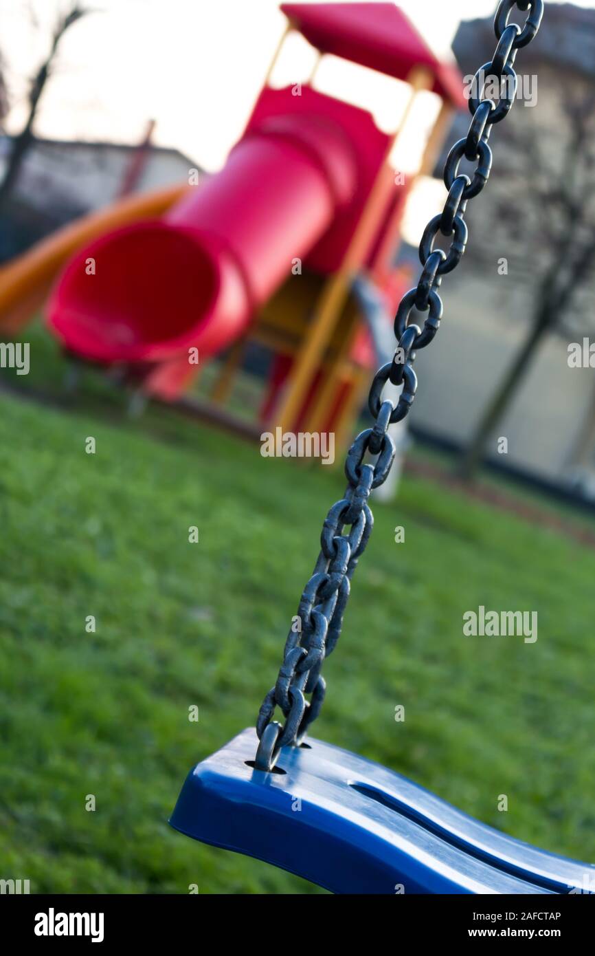children's playground in the gras with blue swing and red slide Stock ...
