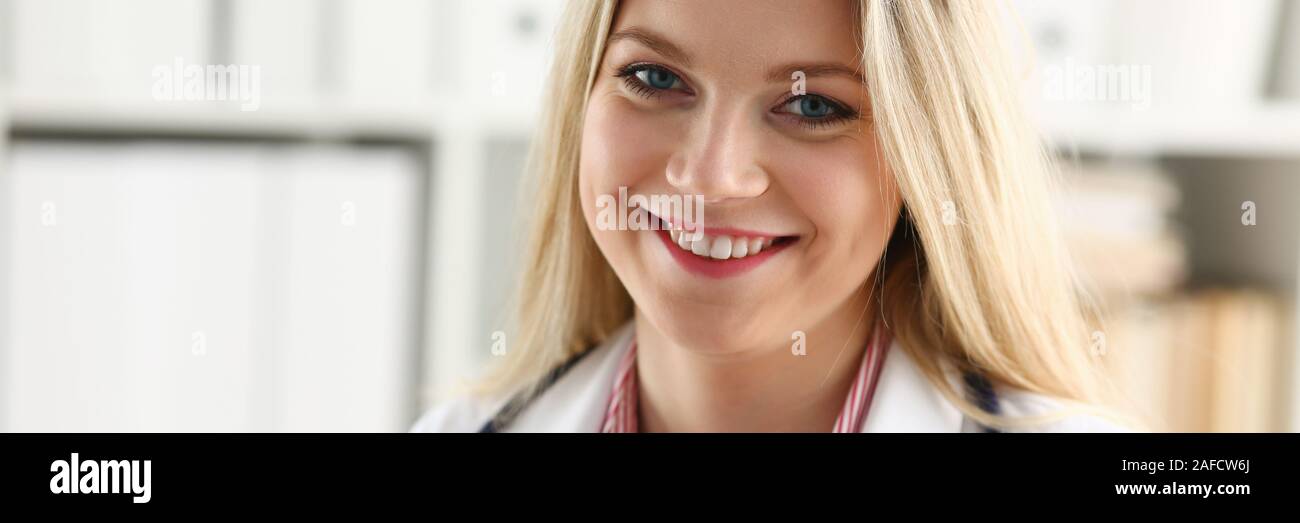 Beautiful smiling female doctor sit at workplace Stock Photo - Alamy