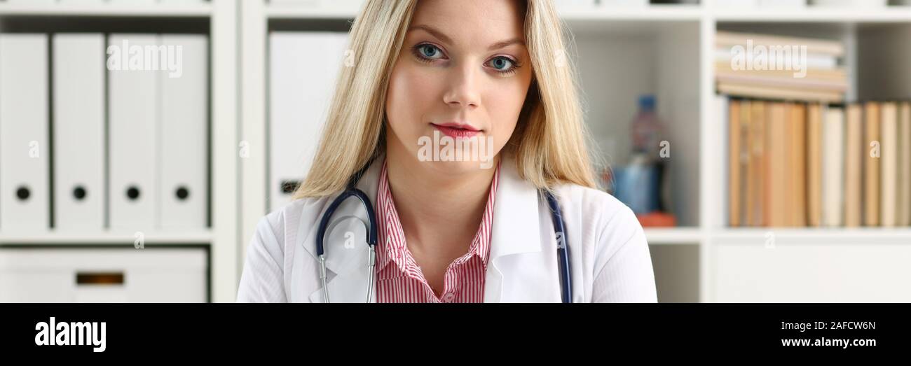 Beautiful smiling female doctor sit at workplace Stock Photo - Alamy