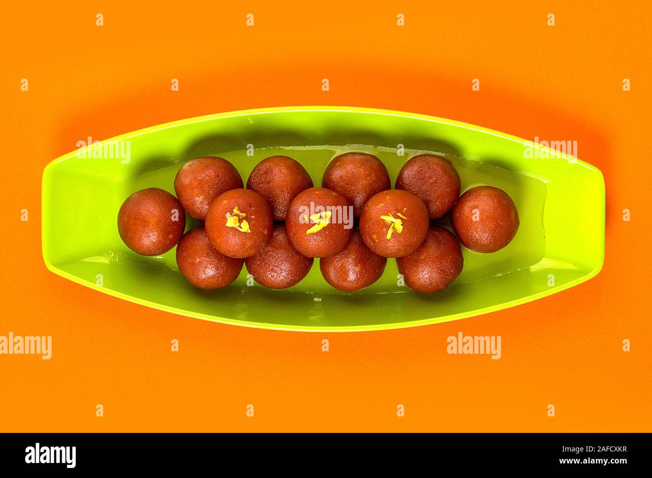 Indian Dessert Gulab Jamun in plate on orange background Stock Photo ...