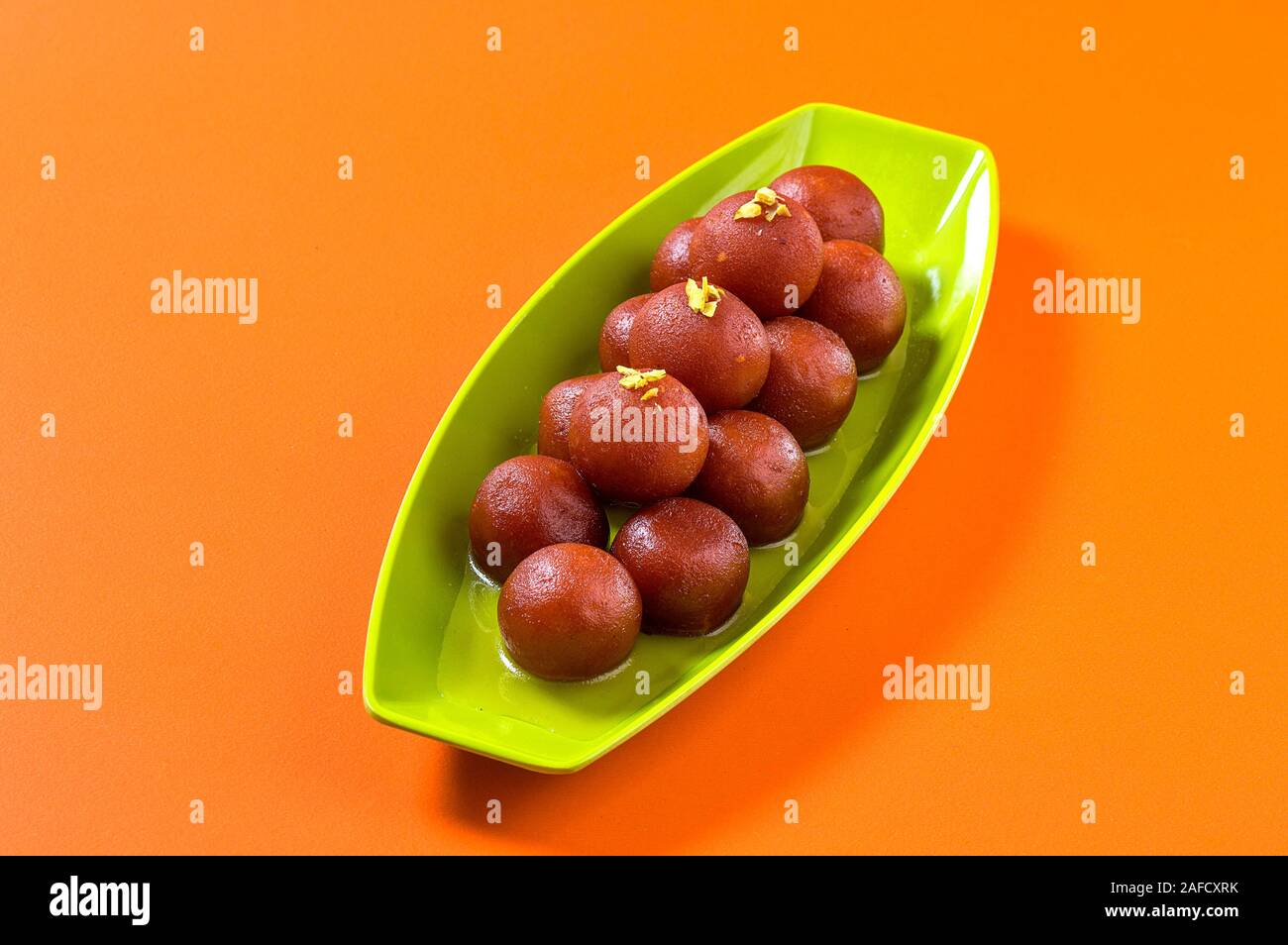 Indian Dessert Gulab Jamun in plate on orange background Stock Photo ...