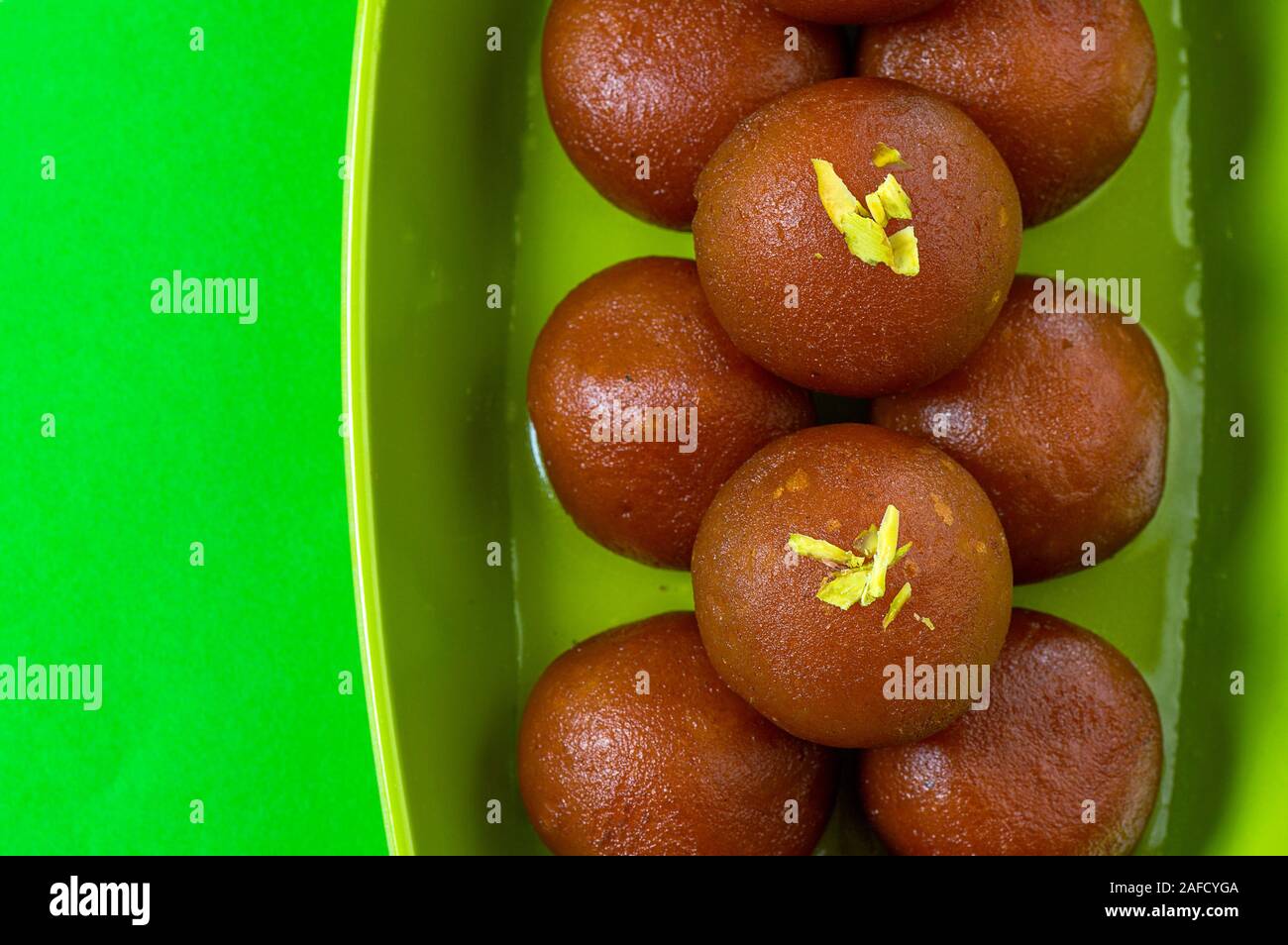 Gulab Jamun in plate on green background. Indian Dessert or Sweet Dish ...