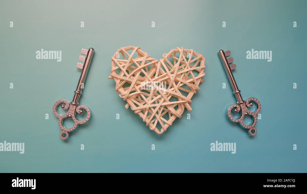 A pair of matching keys on two sides of a woven heart Stock Photo - Alamy