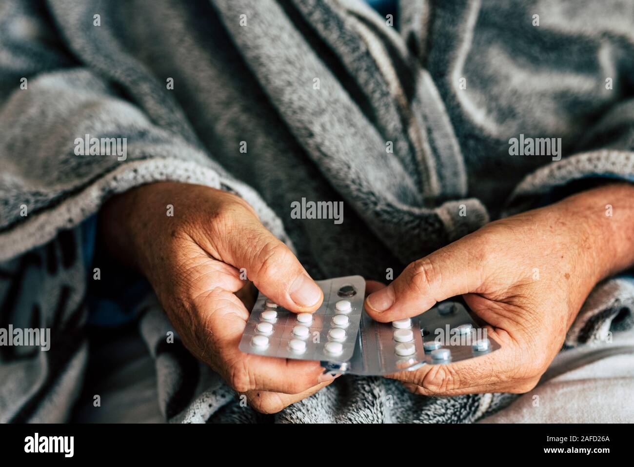 Close up of old senior hands with pills and tablets for cold ill ...