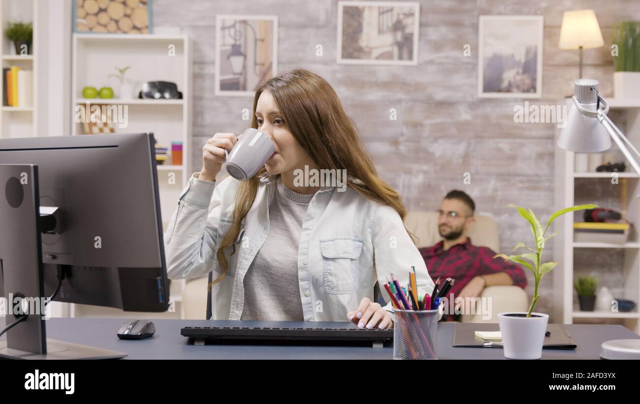 Beautiful female freelancer typing on computer while working from home ...