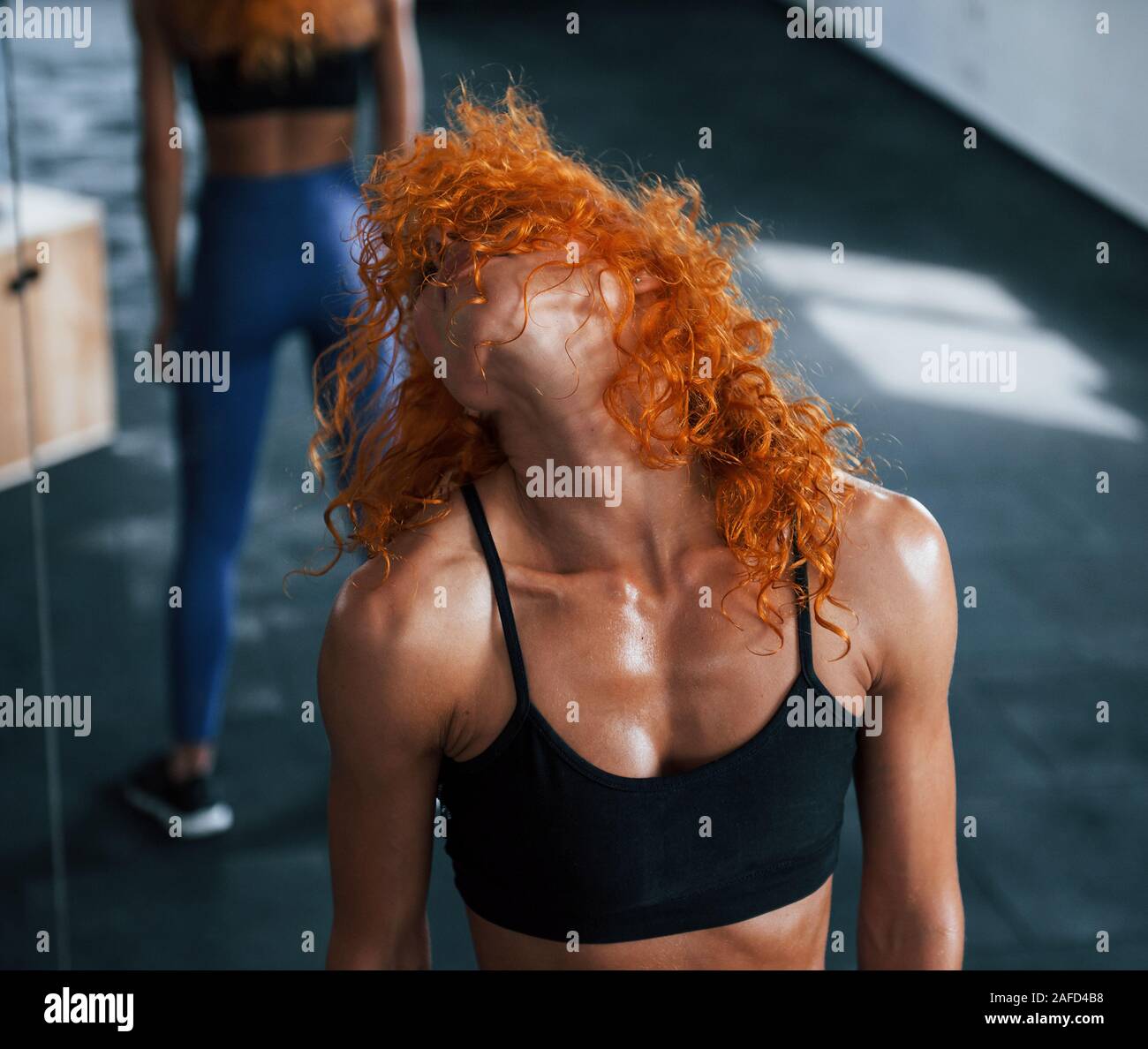 Sporty redhead girl have fitness day in gym at daytime. Muscular body ...